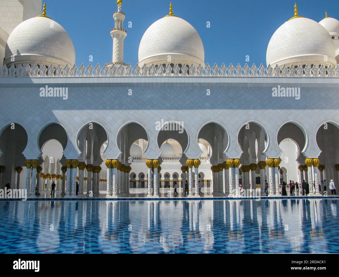 bright white Sheikh Zayed Grand Mosque with golden domes against the ...
