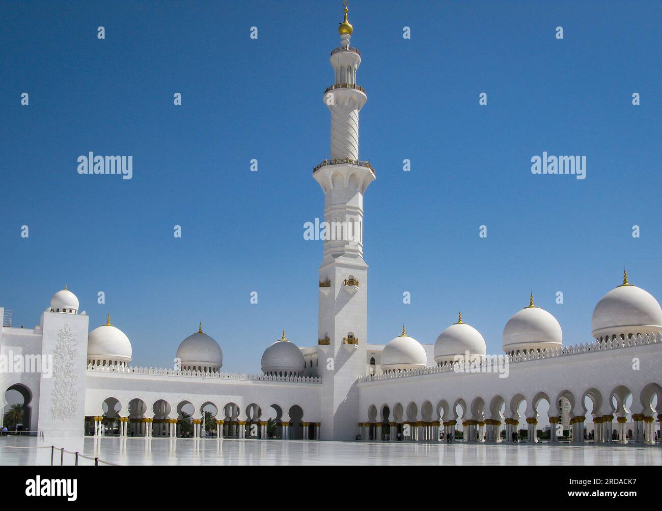 bright white Sheikh Zayed Grand Mosque with golden domes against the ...