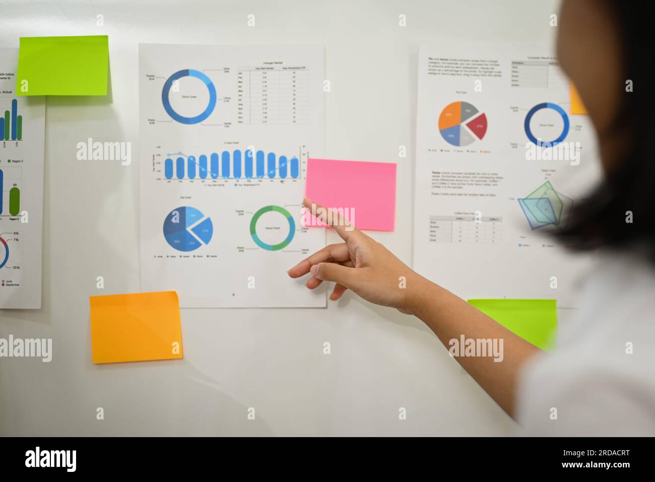 Female economist analyzing sales statistics document, discussing ...