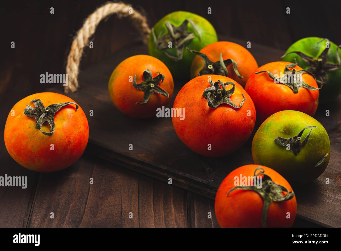 Collection of whole colored tomatoes served on a wooden rustic ...