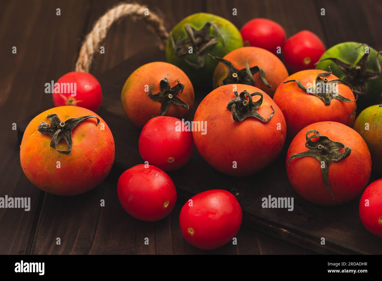 Collection of whole colored tomatoes served on a wooden rustic ...