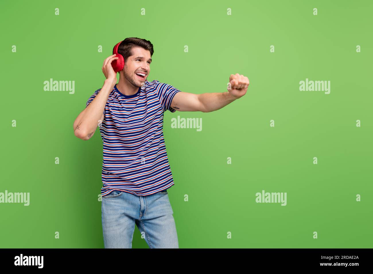 Photo of satisfied cool man with stubble dressed striped clothes touch ...