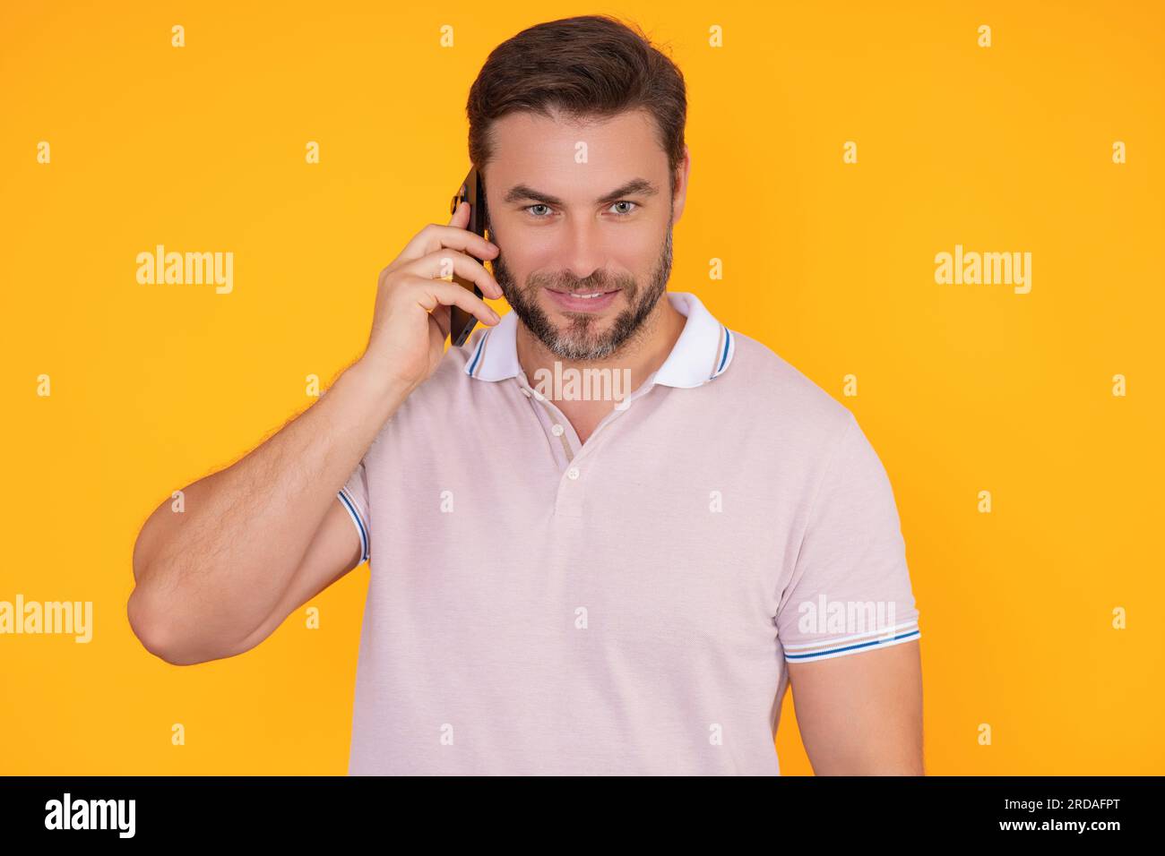 Portrait of a cheerful man using mobile phone isolated over studio ...