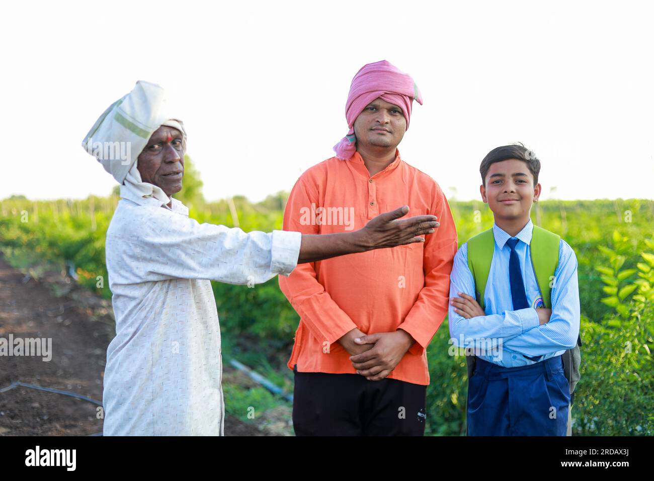 Indian three people standing in farm, farmer and his two son in farm ...