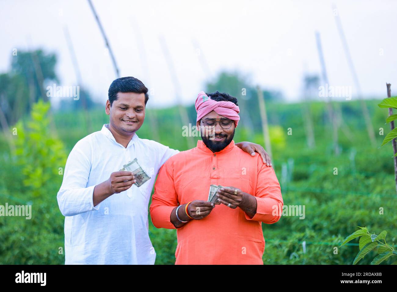 Indian farmer giving money to his worker , smart farmer, young farmer ...
