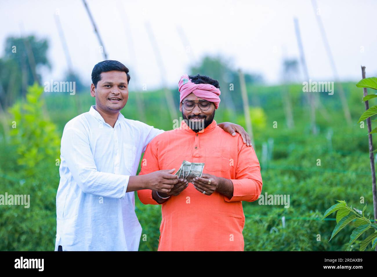 Indian farmer giving money to his worker , smart farmer, young farmer ...