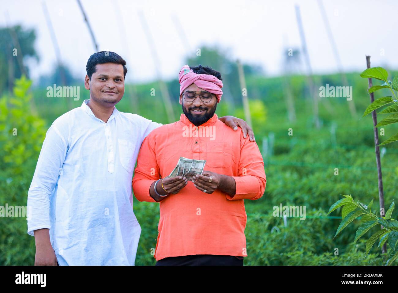 Indian farmer giving money to his worker , smart farmer, young farmer ...