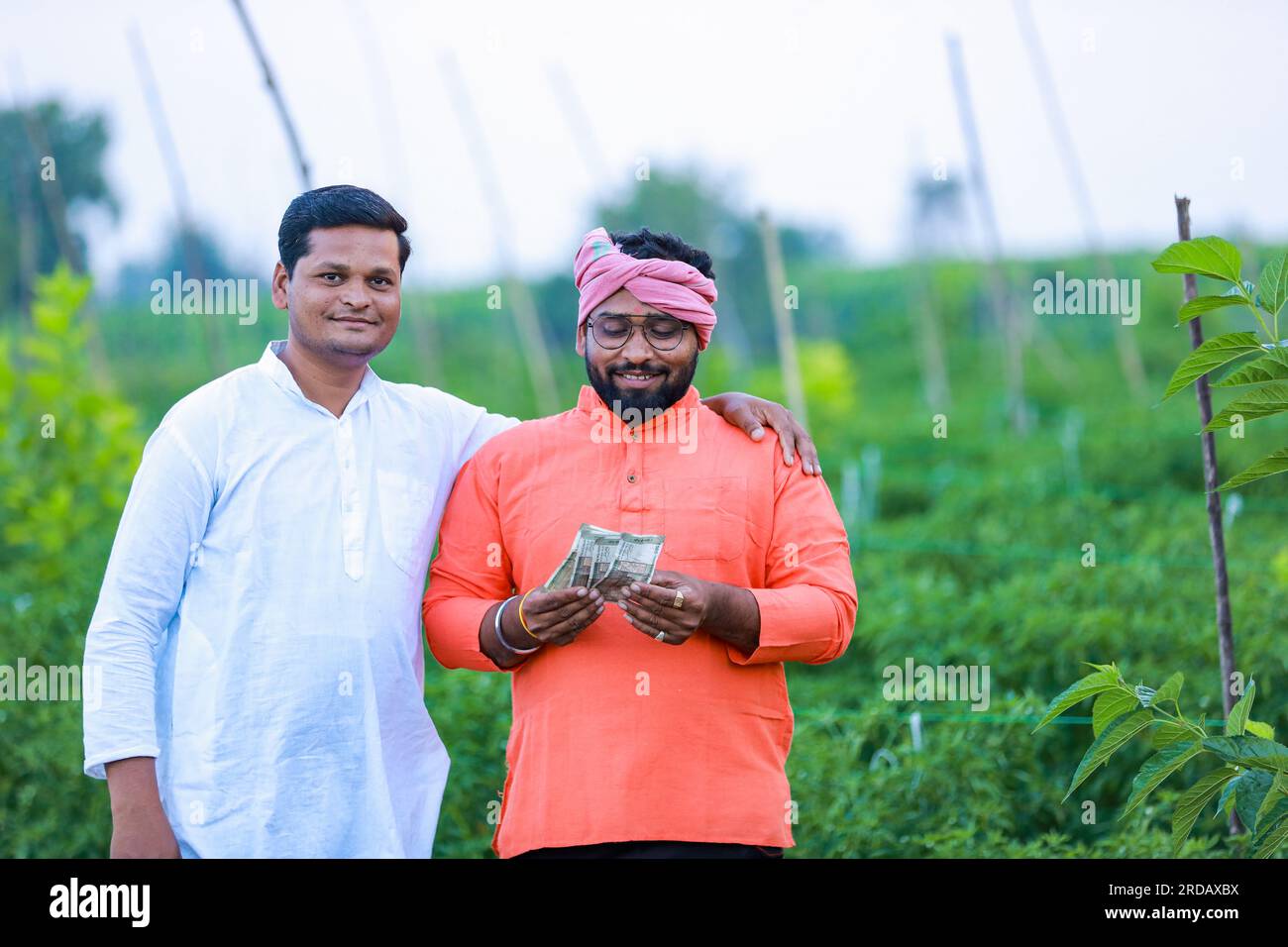Indian farmer giving money to his worker , smart farmer, young farmer ...