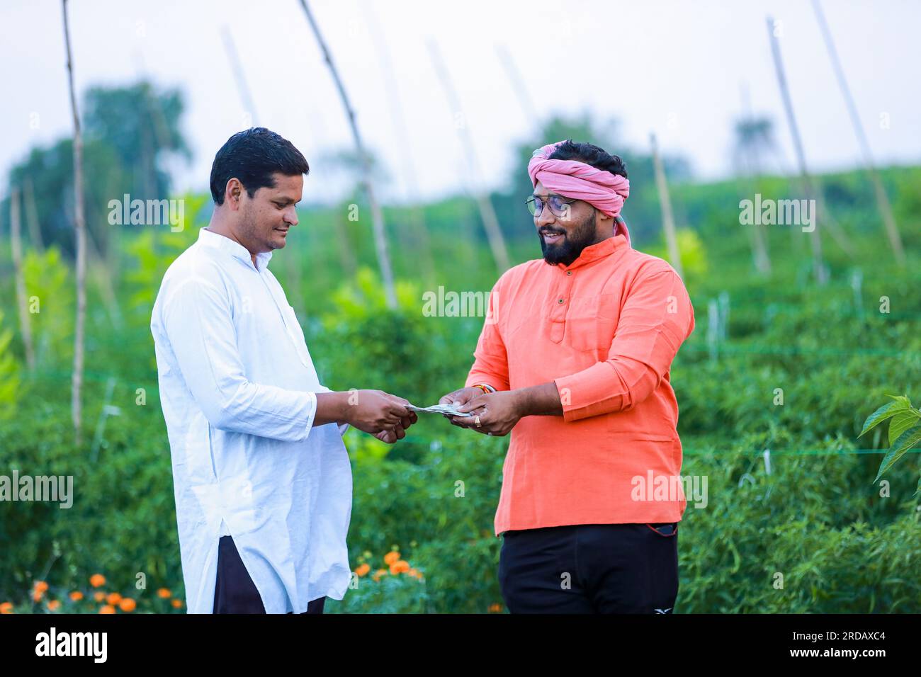 Indian farmer giving money to his worker , smart farmer, young farmer ...