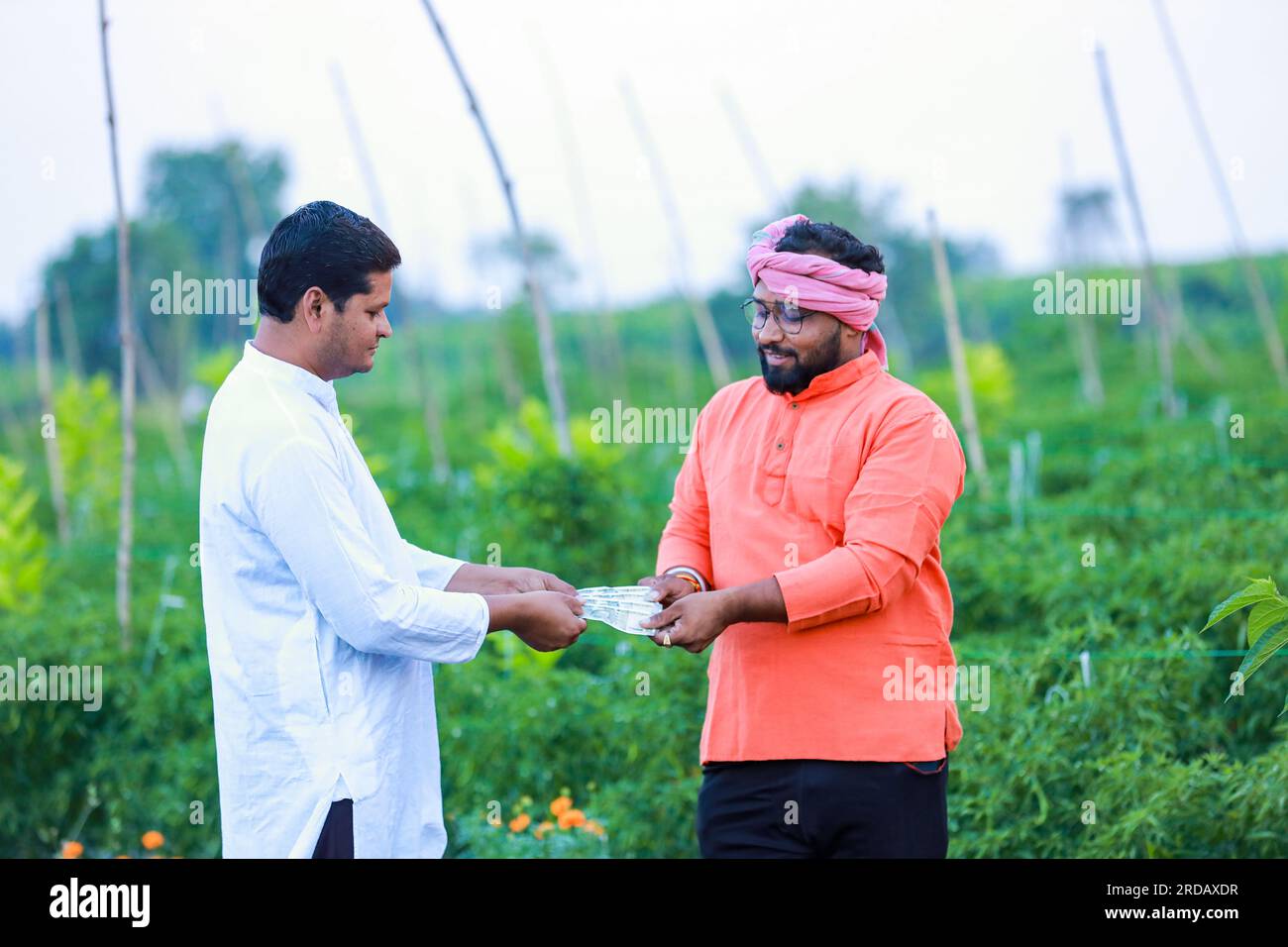 Indian farmer giving money to his worker , smart farmer, young farmer ...