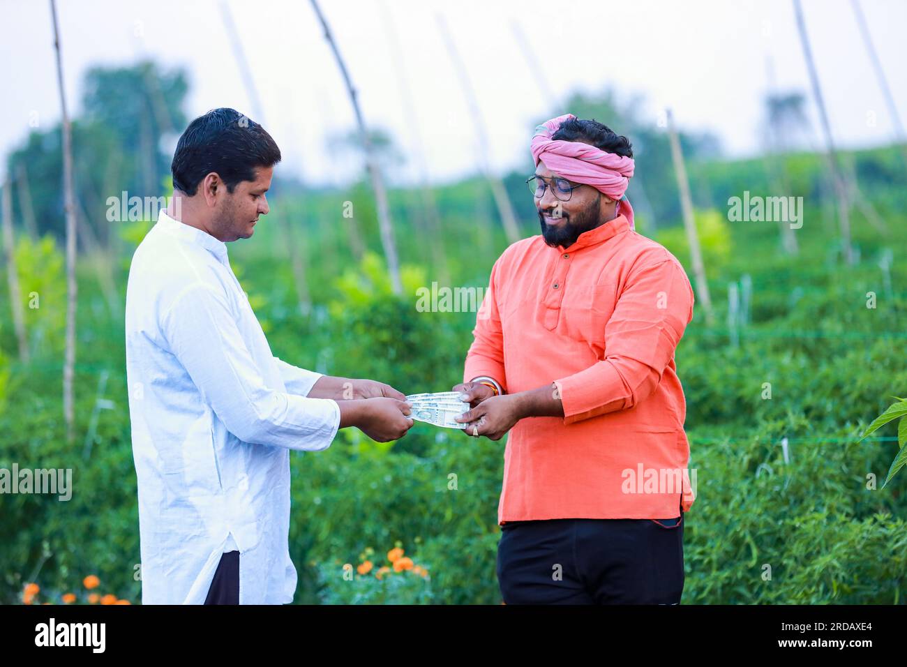 Indian farmer giving money to his worker , smart farmer, young farmer ...