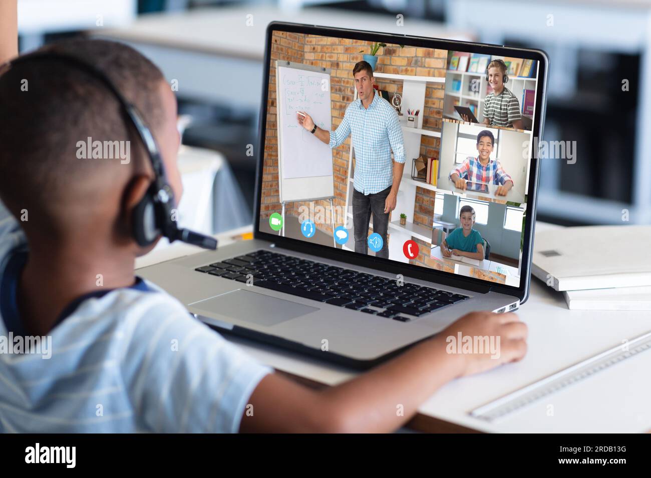 African american boy looking at students and teacher on laptop screen ...
