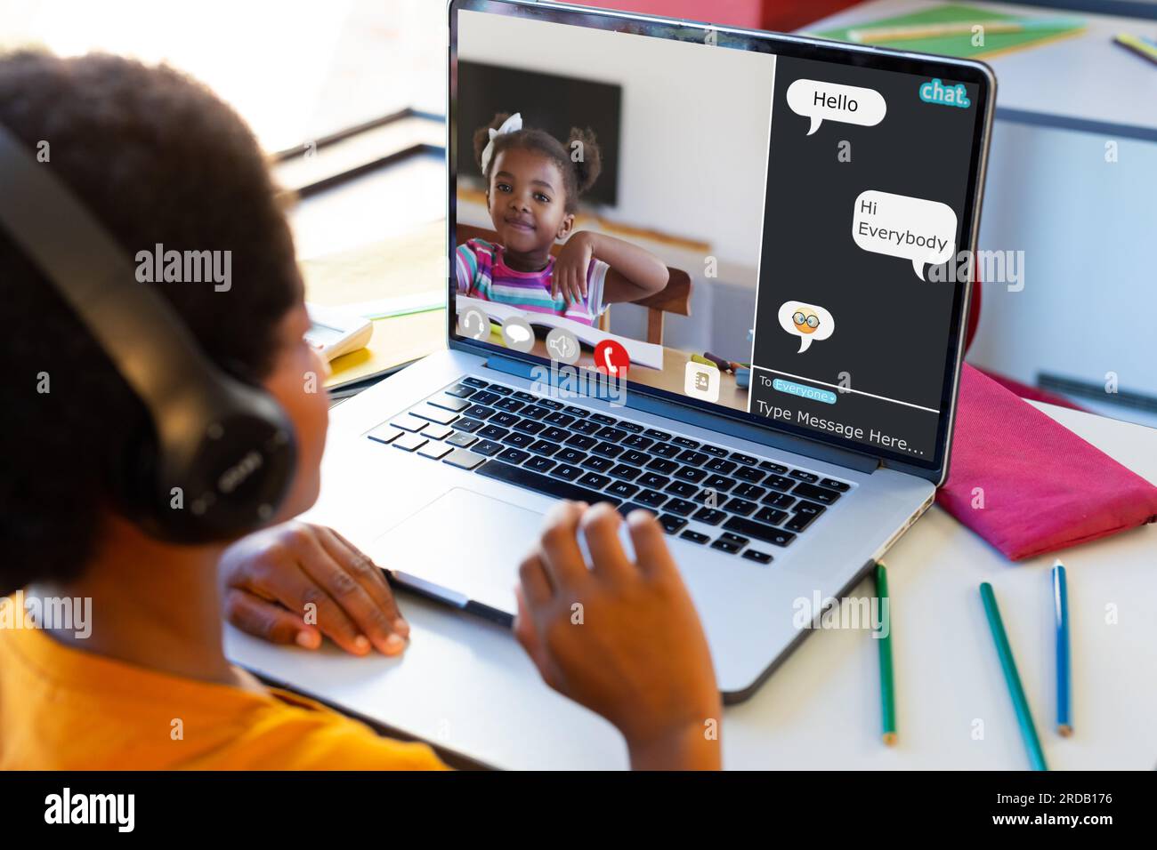 Biracial boy in headphones attending online class over laptop with girl ...