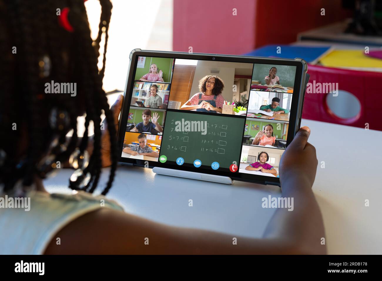 African american girl holding digital tablet with teacher and students ...