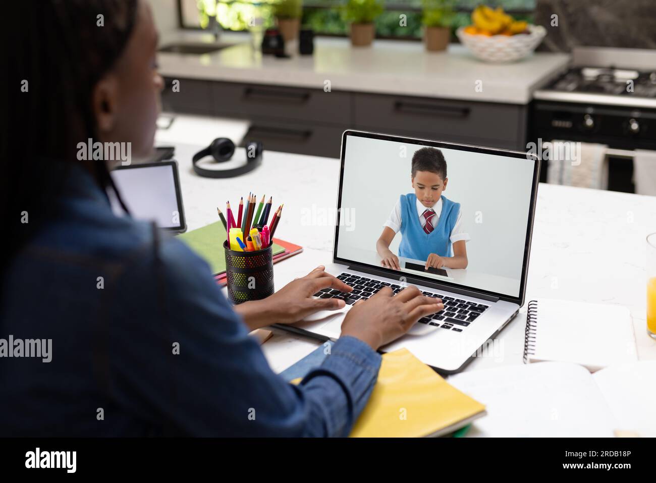 African american teenage boy talking with friend over video call while ...