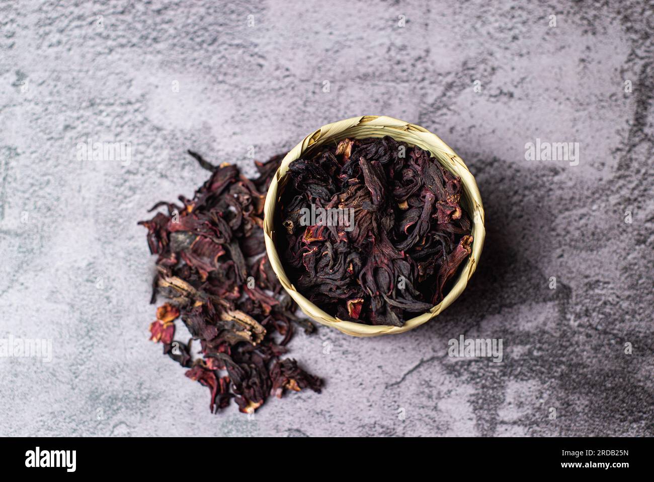 Jamaica flower in woven fiber basket on concrete table. Hibiscus flower ...