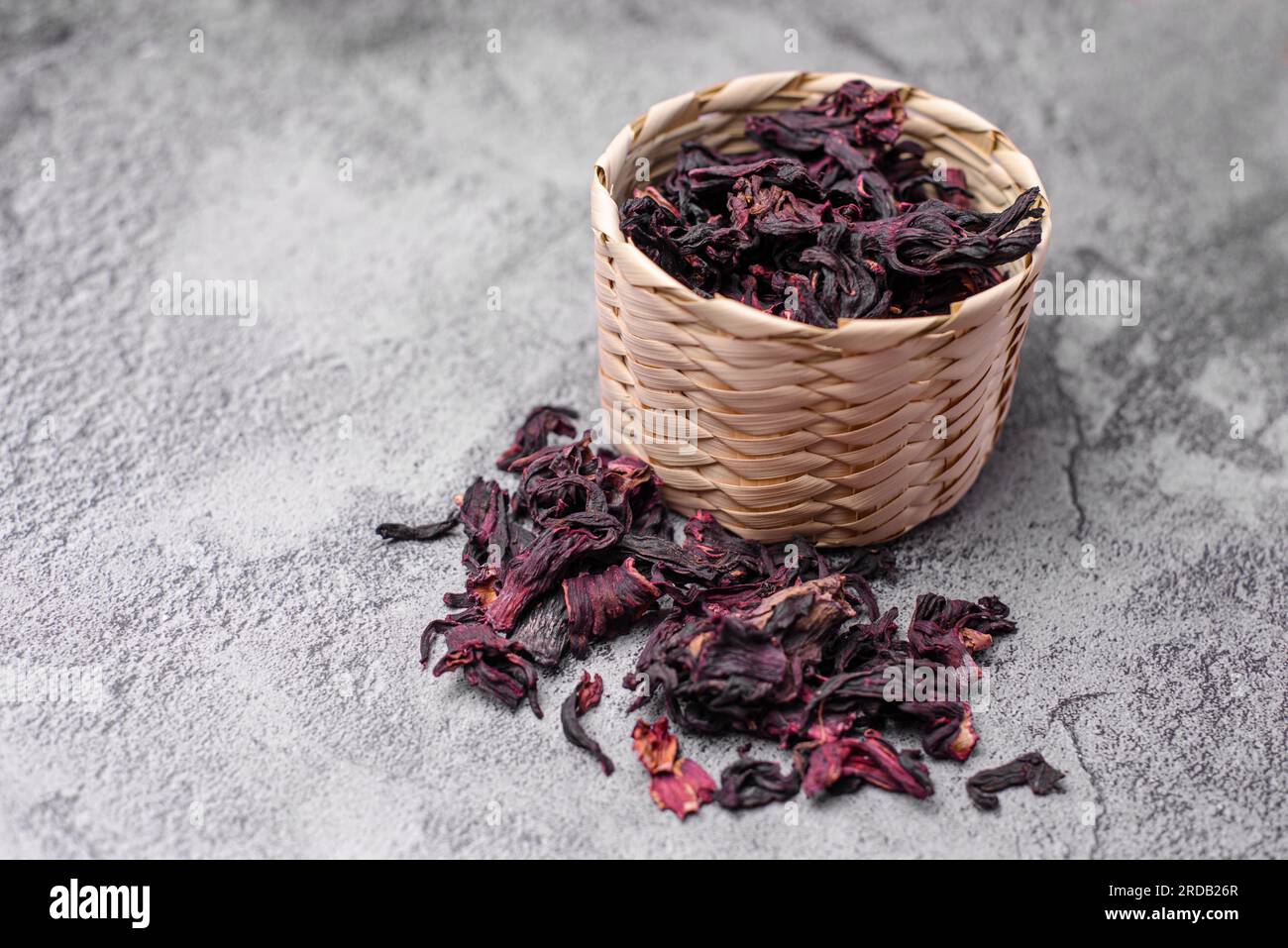 Jamaica flower in woven fiber basket on concrete table. Hibiscus flower ...