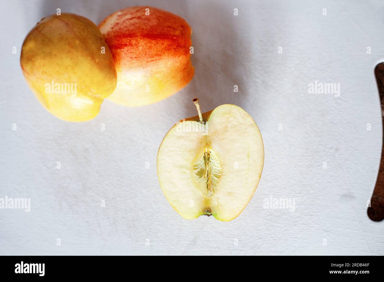 Sliced bisected raw Gala apples on white cutting board, top view. Half ...