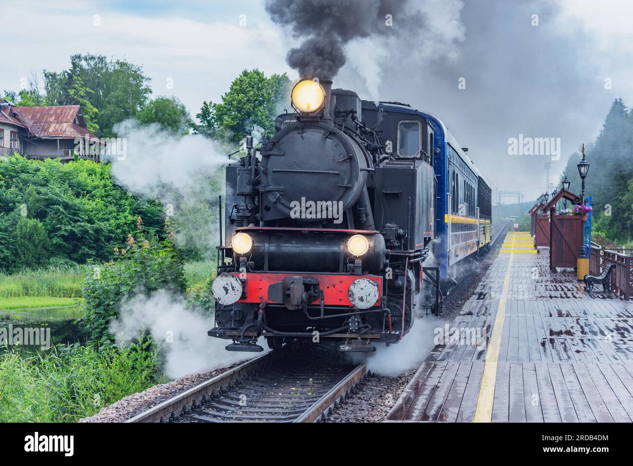 Retro steam train approaches to the platform Stock Photo - Alamy