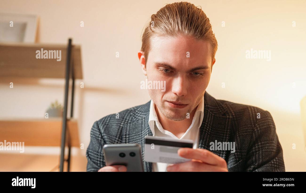 Mobile scam banking fraud confused man credit card Stock Photo - Alamy