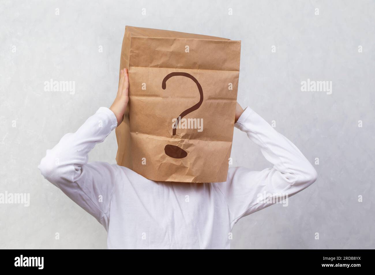 Anonymous man on a gray background with a cardboard box on his head ...