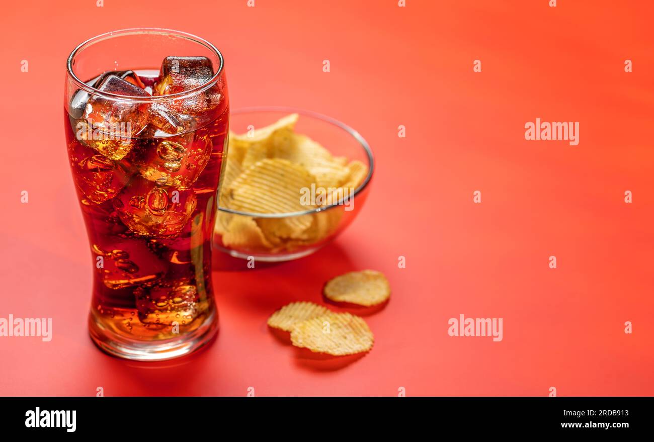 Refreshing glass of cola with ice, accompanied by a serving of crispy ...