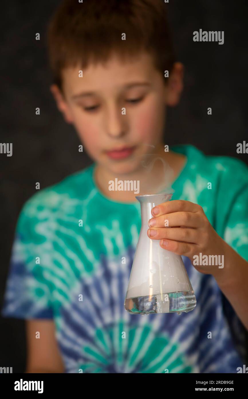 A boy conducts a scientific chemical experiment with liquid nitrogen. A ...