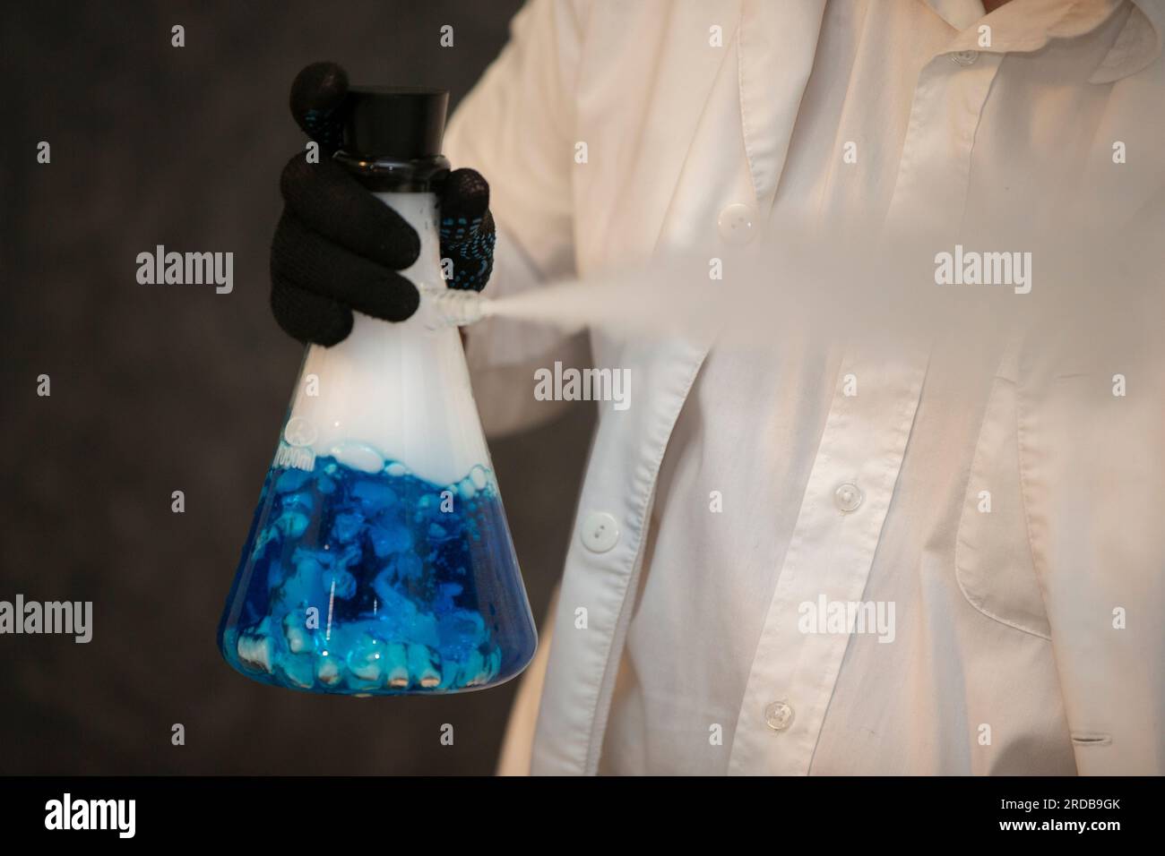 Chemical flask with a blue solution in the hands of a laboratory ...
