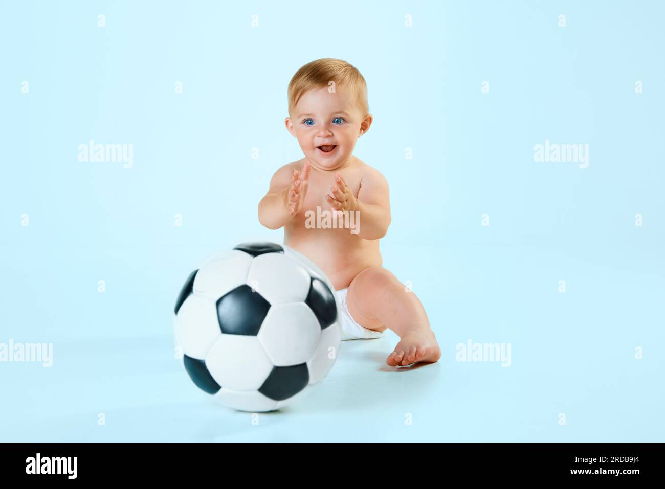 Happy, smiling little baby, toddler in diaper playing with football ...