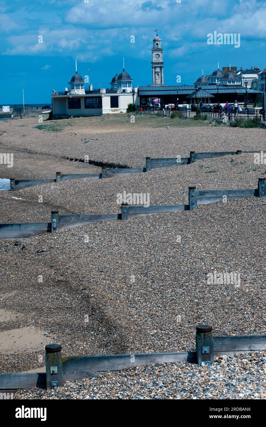 View, at low tide, looking along the beach towards the clock tower and ...