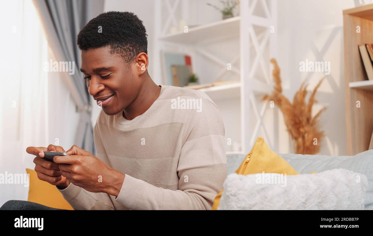 Cell gaming phone entertainment happy man home Stock Photo - Alamy