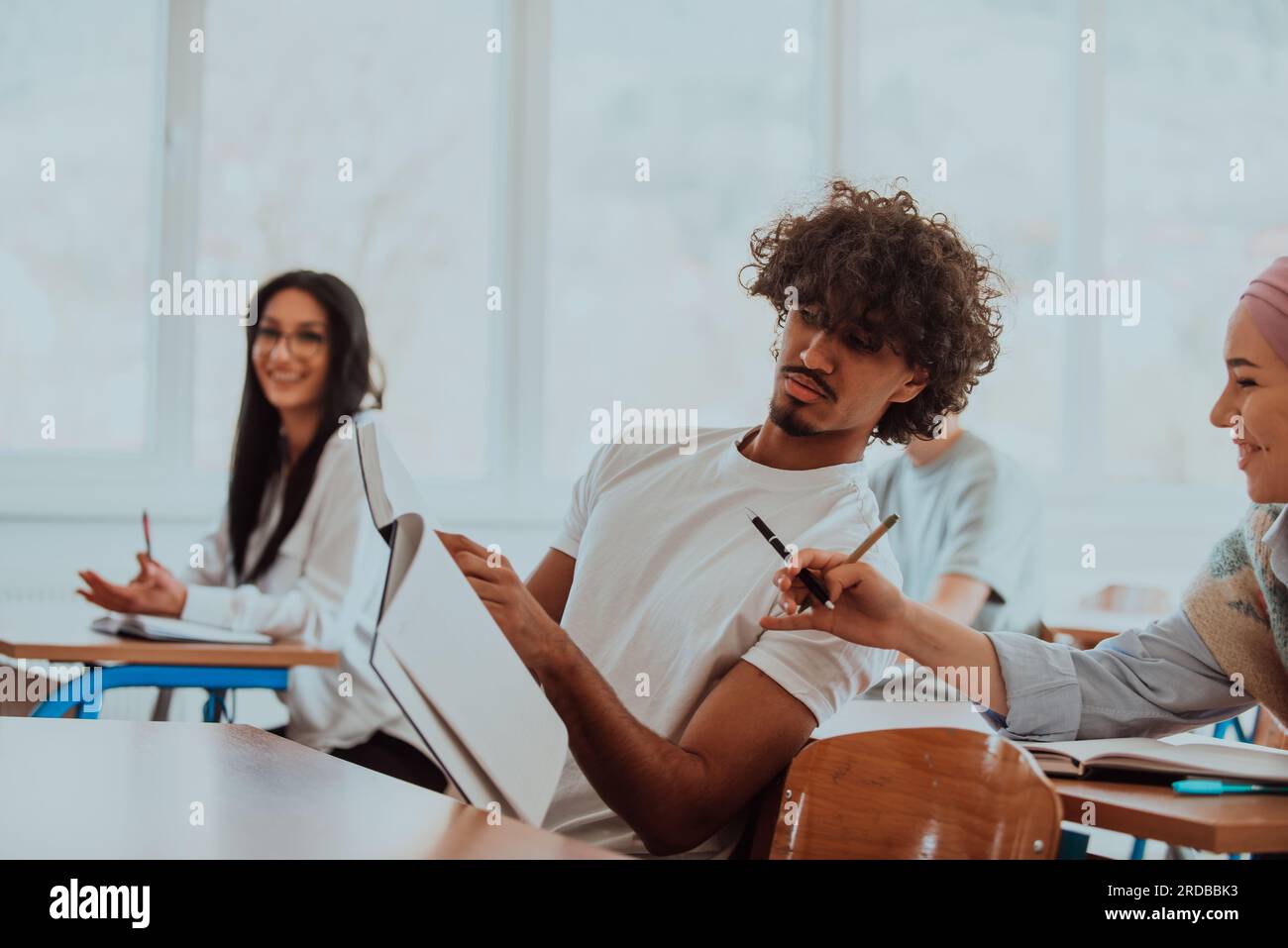 A group of diverse students engages in lively discussion as they ...