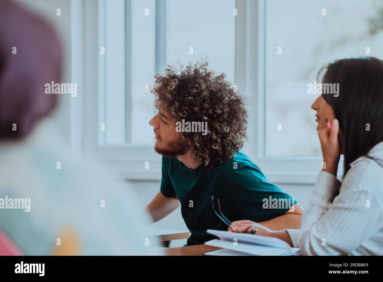 A group of diverse students engages in lively discussion as they ...