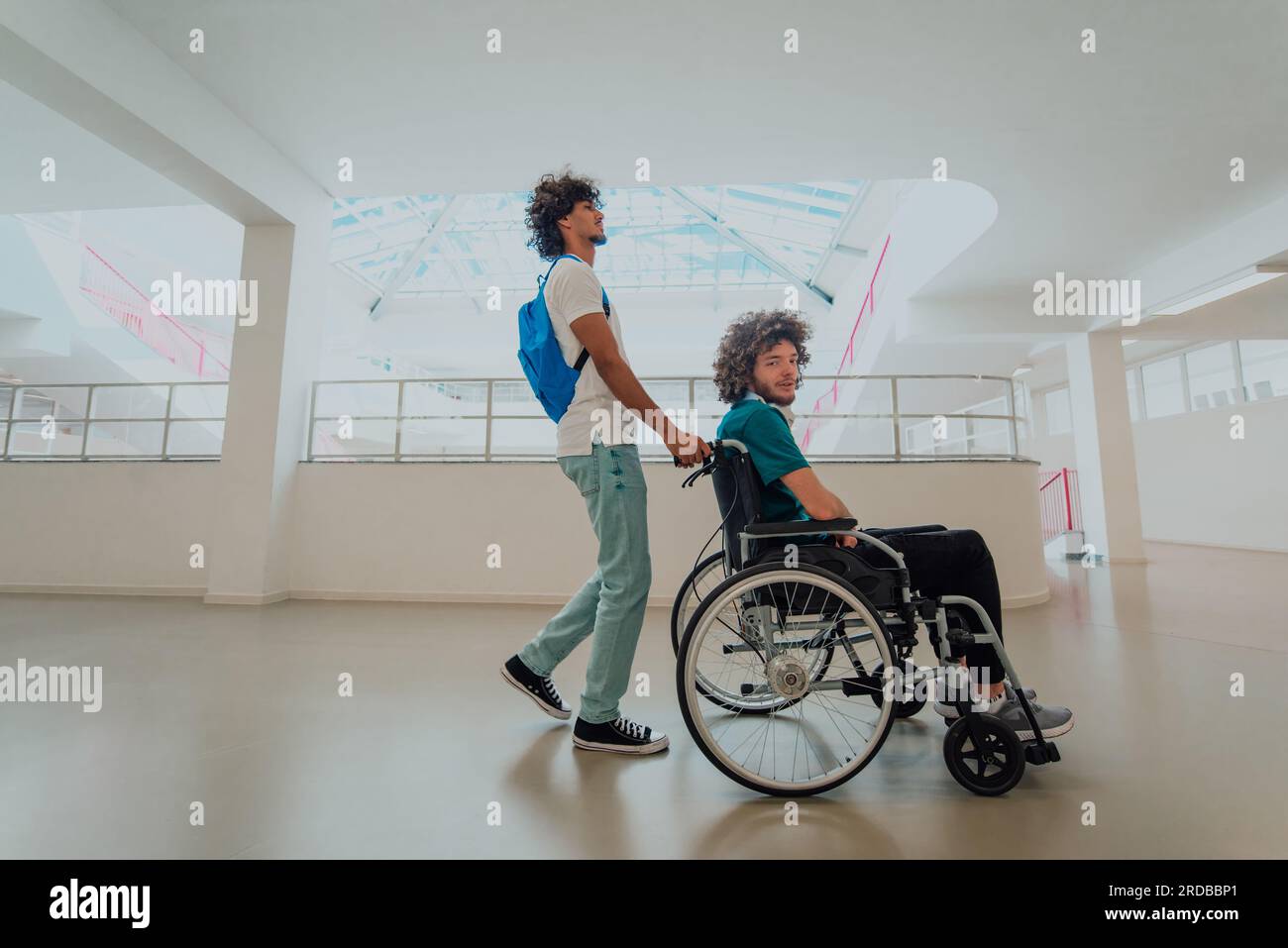 African American student pushing his friend's wheelchair through a ...
