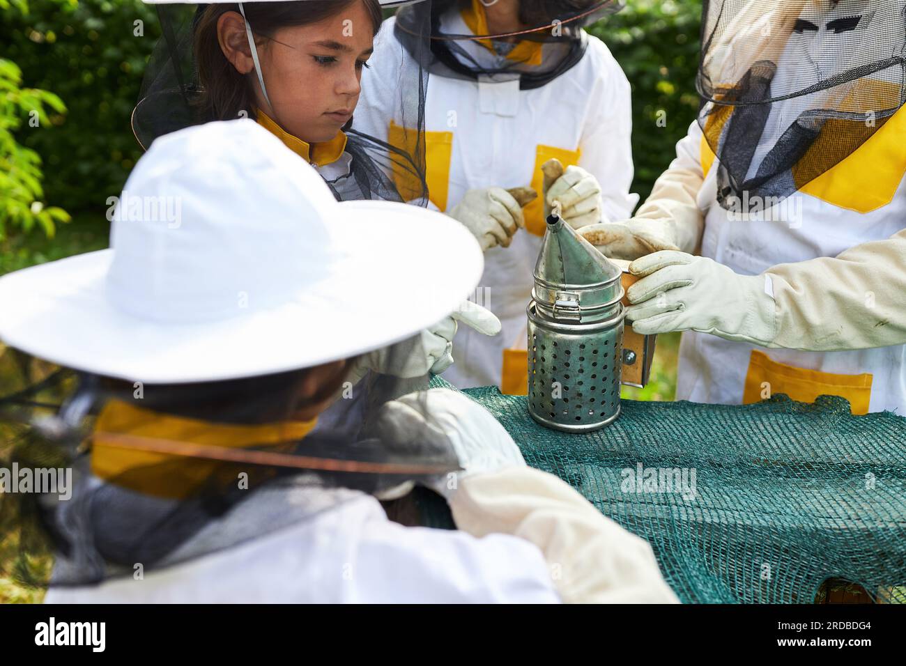 Girls learning about apiculture while examining smoker with senior ...