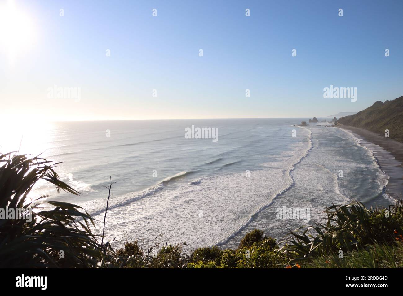 Sunrise in a wavy beach Stock Photo - Alamy