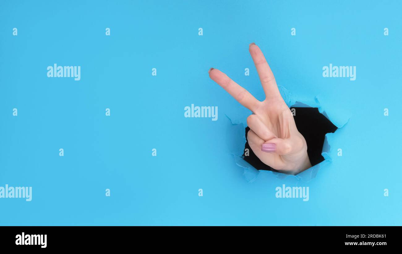 V sign. Victory gesture. Female hand showing two fingers up inside ...