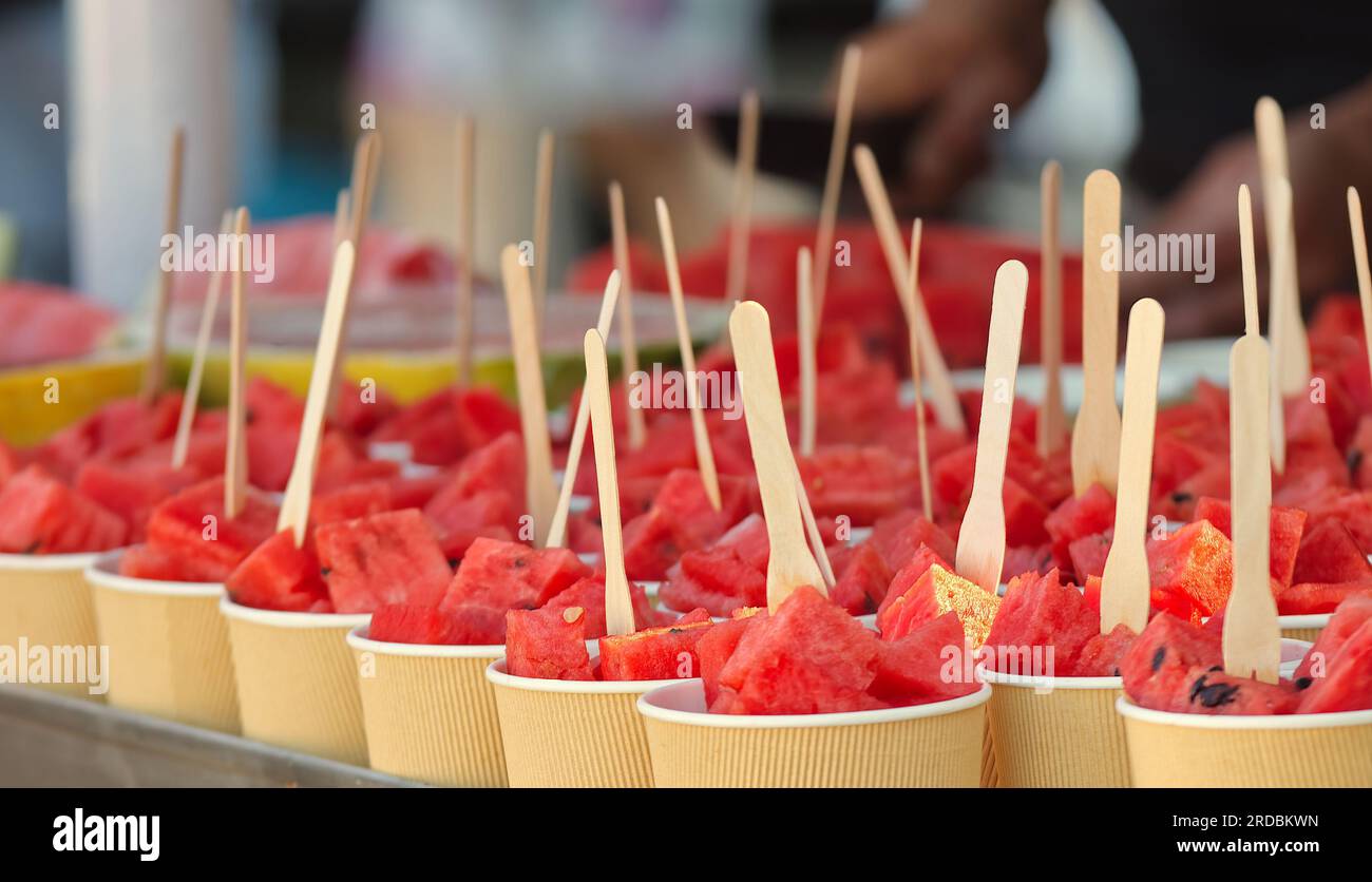 Selling portions of sliced watermelon to visitors of the traditional ...