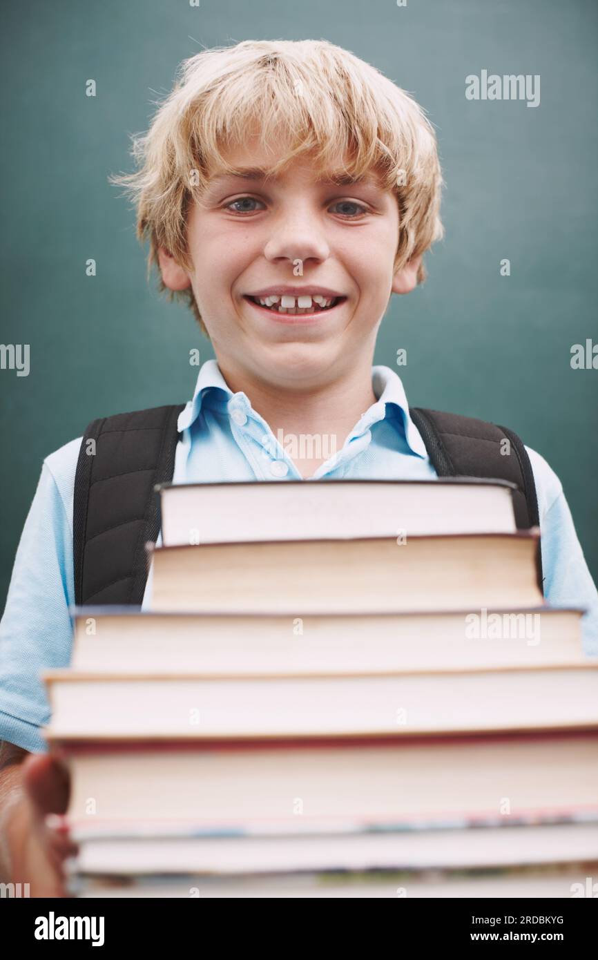 I cant wait to read them all. A cute young boy carrying a large stack ...