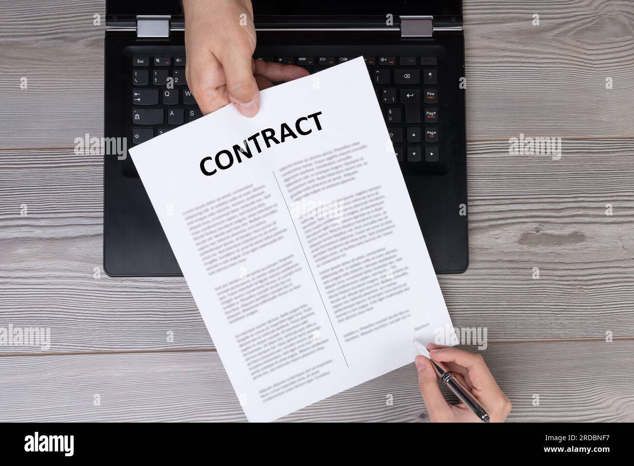 Top-down view: hand ready to sign a contract via computer screen ...