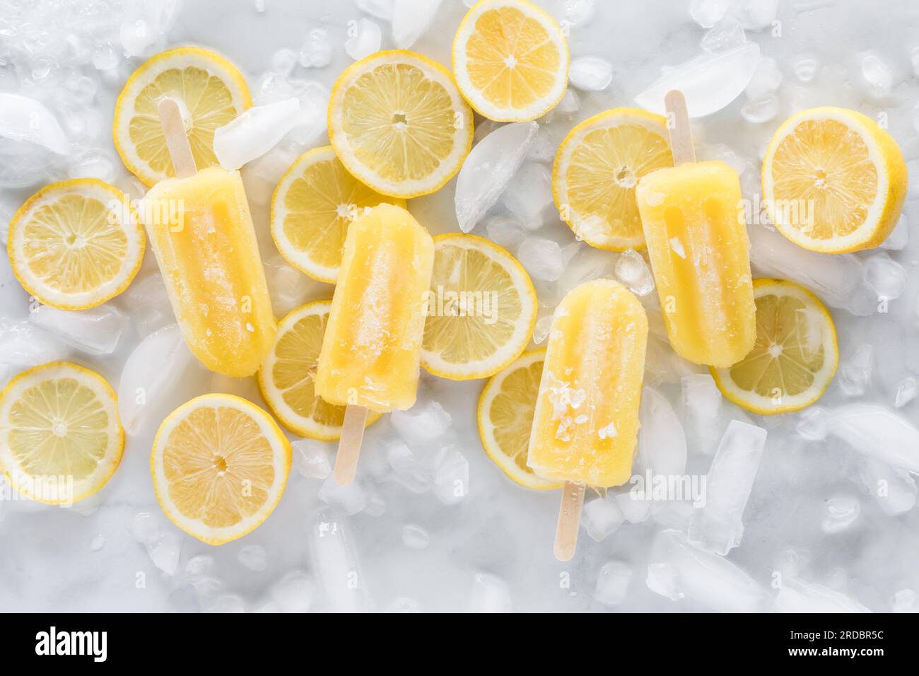 Lemonade ice pops on a bed of lemon slices with ice cubes Stock Photo - Alamy