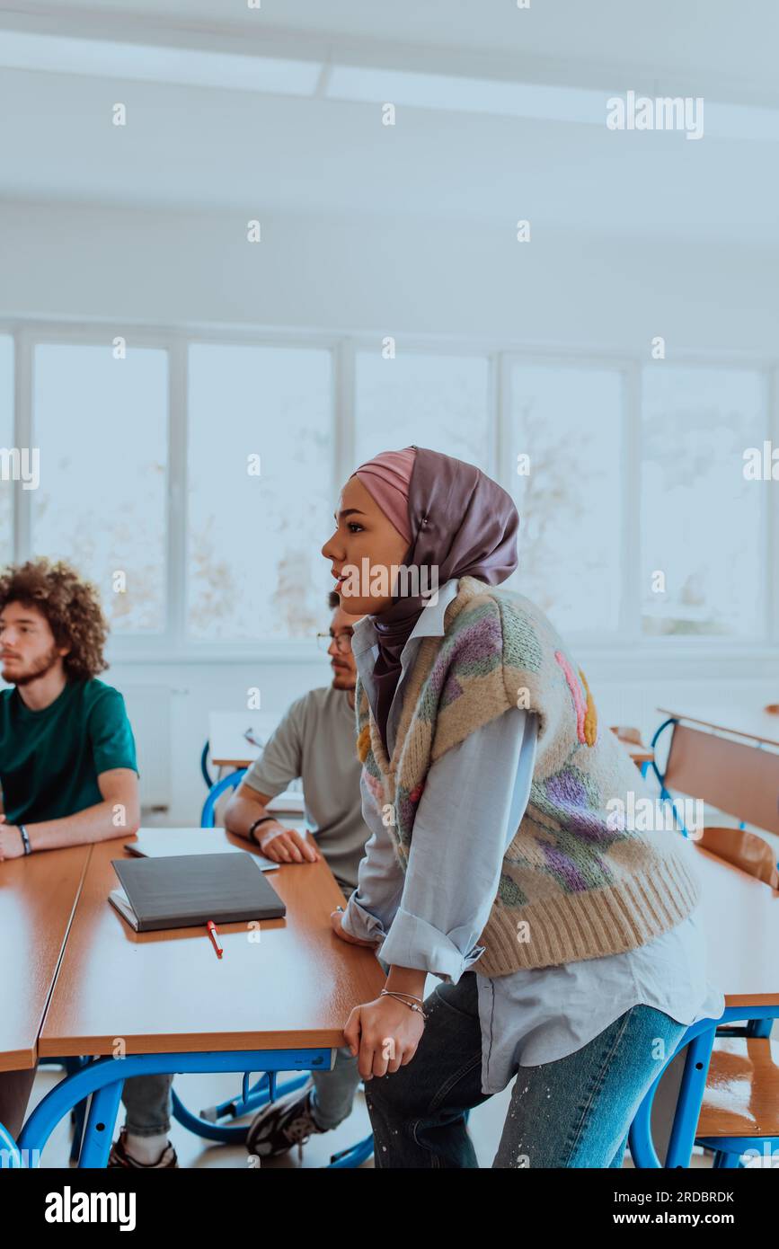 A diverse group of students gathers in a modern school classroom ...