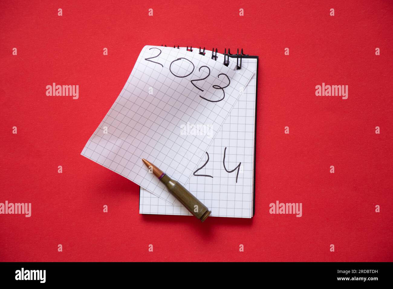 Notepad with text 2023 and 2024 and a bullet turns the page of the ...