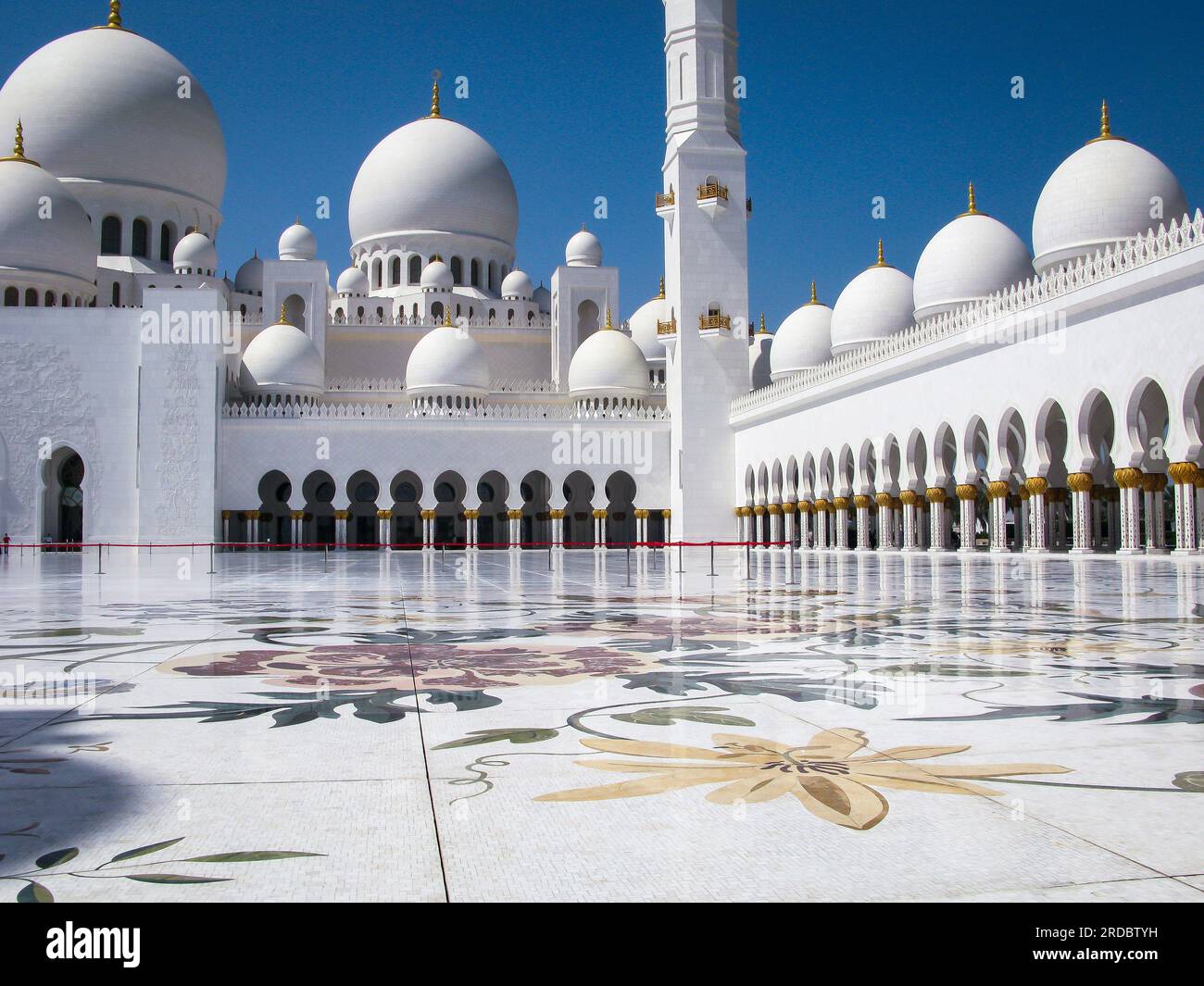 bright white Sheikh Zayed Grand Mosque with golden domes against the ...