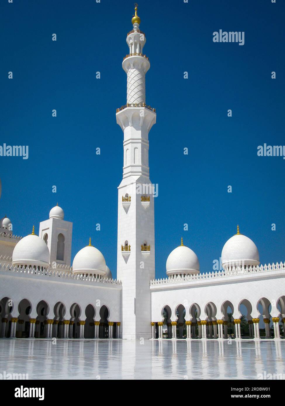 bright white Sheikh Zayed Grand Mosque with golden domes against the ...
