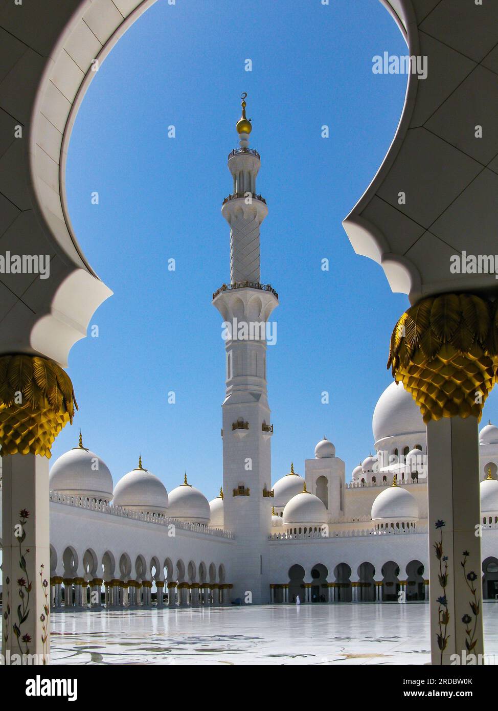 bright white Sheikh Zayed Grand Mosque with golden domes against the ...