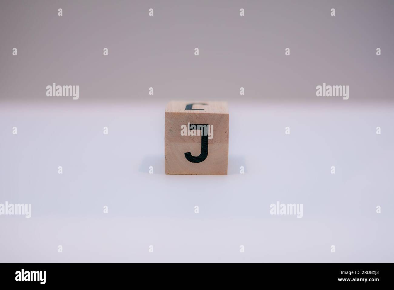 Wooden block written "J" with a white background Stock Photo - Alamy