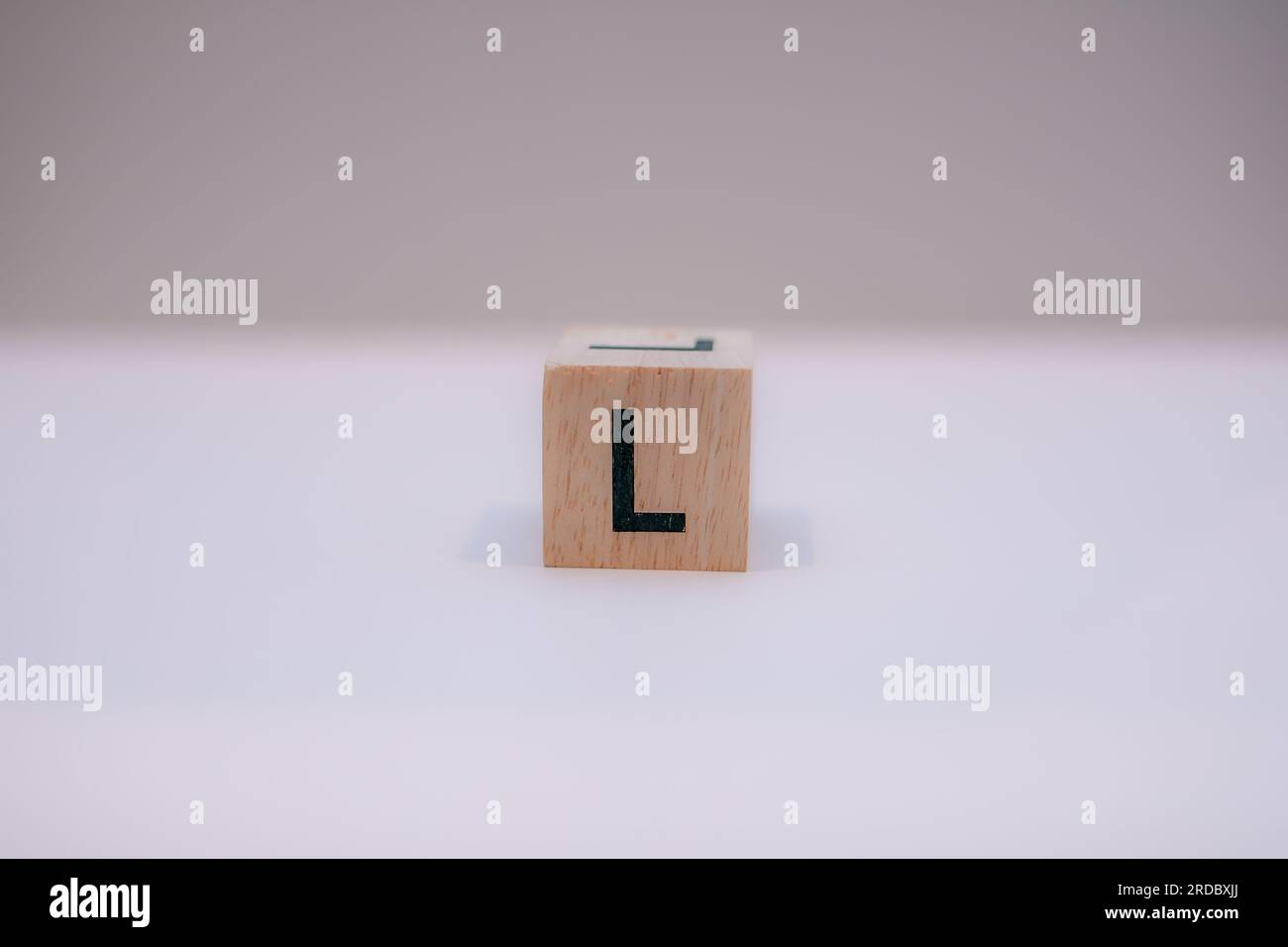 Wooden block written "L" with a white background Stock Photo - Alamy