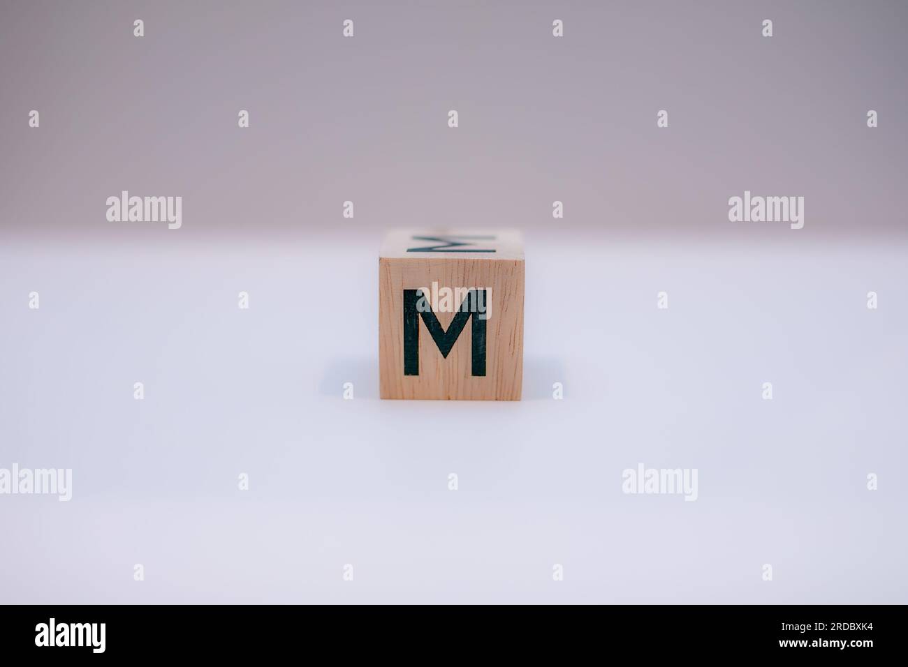 Wooden block written "M" with a white background Stock Photo - Alamy