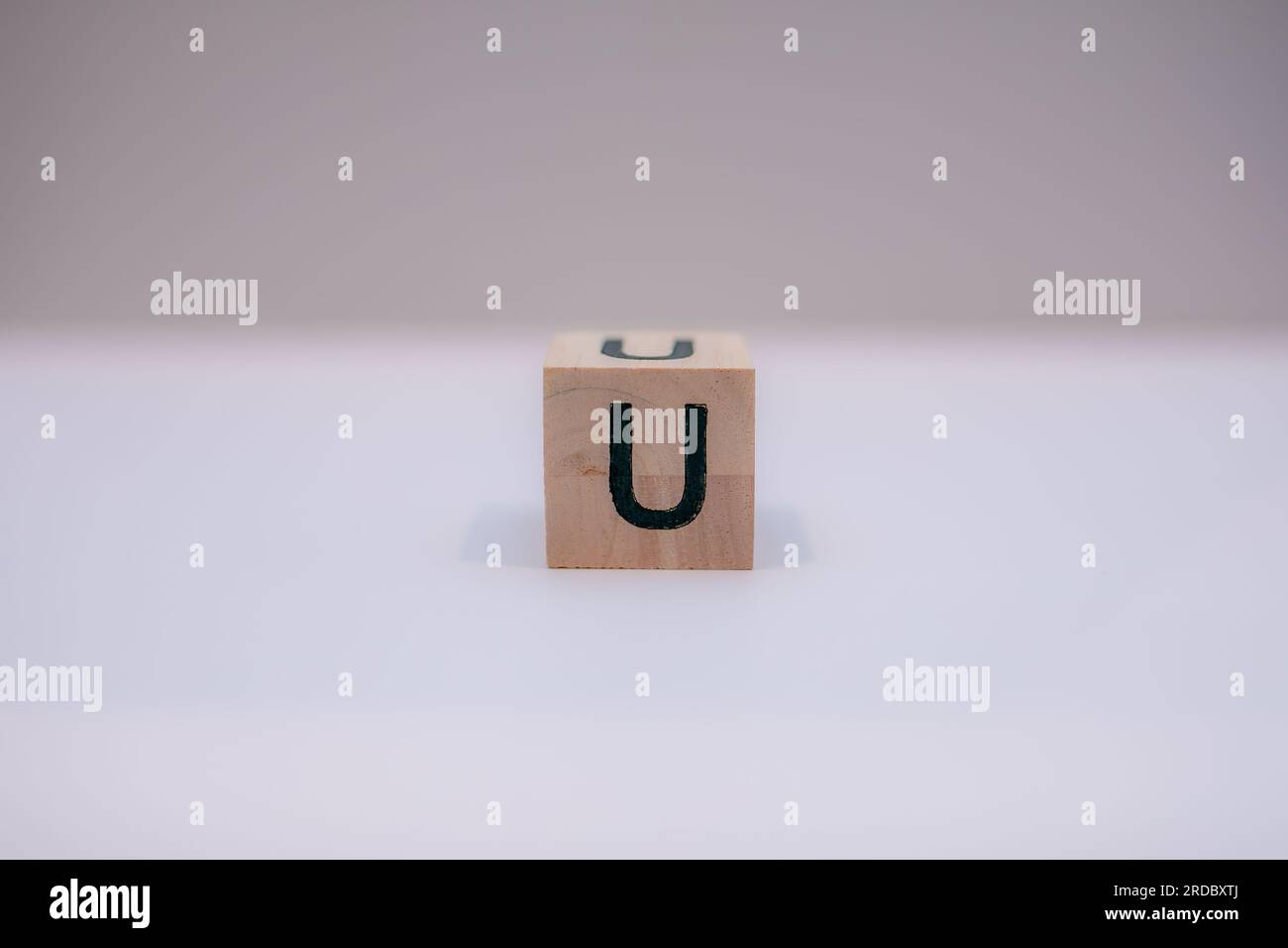 Wooden block written "U" with a white background Stock Photo - Alamy
